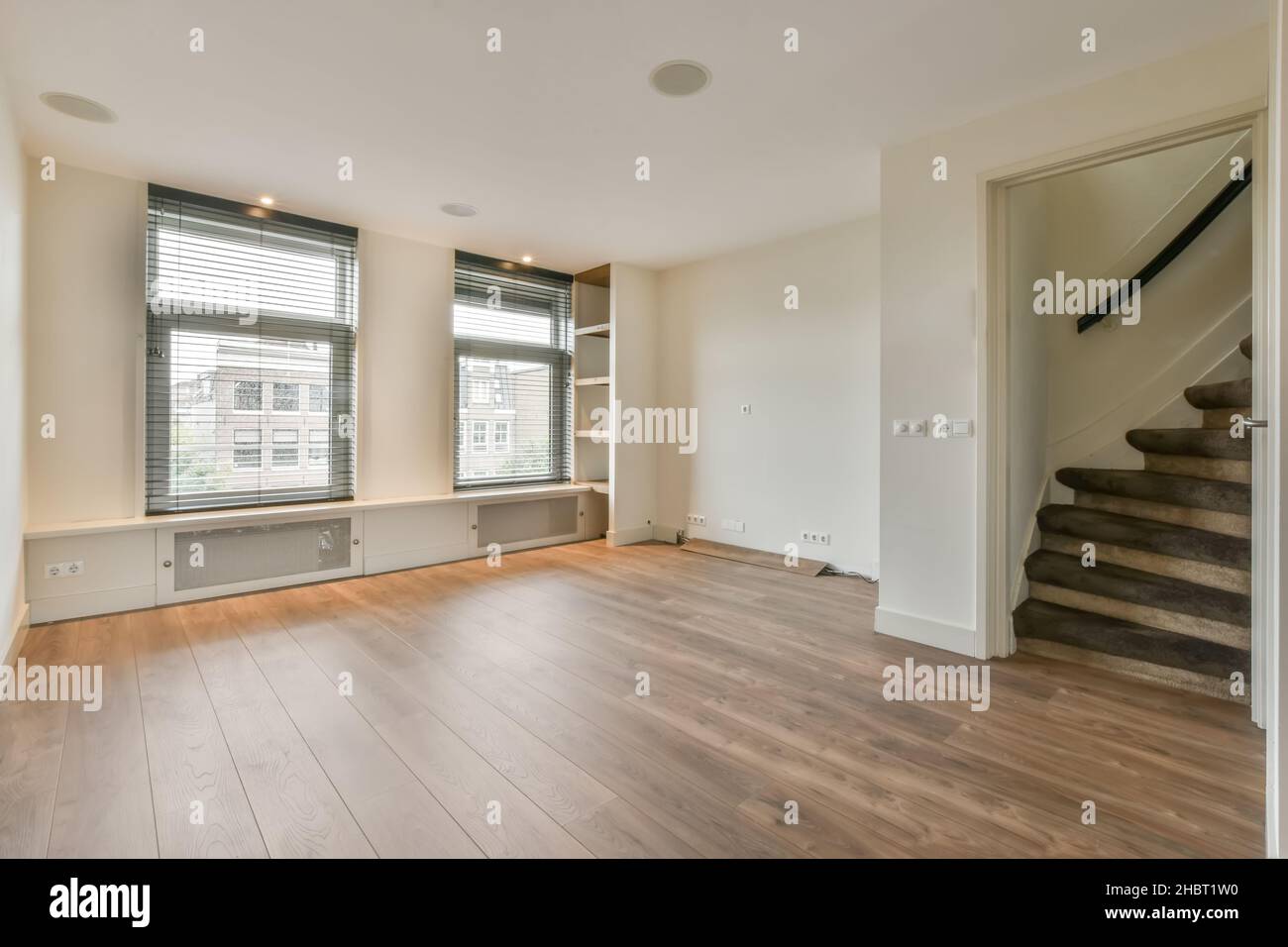 Large room with dark parquet floor and adjoining staircase Stock Photo ...