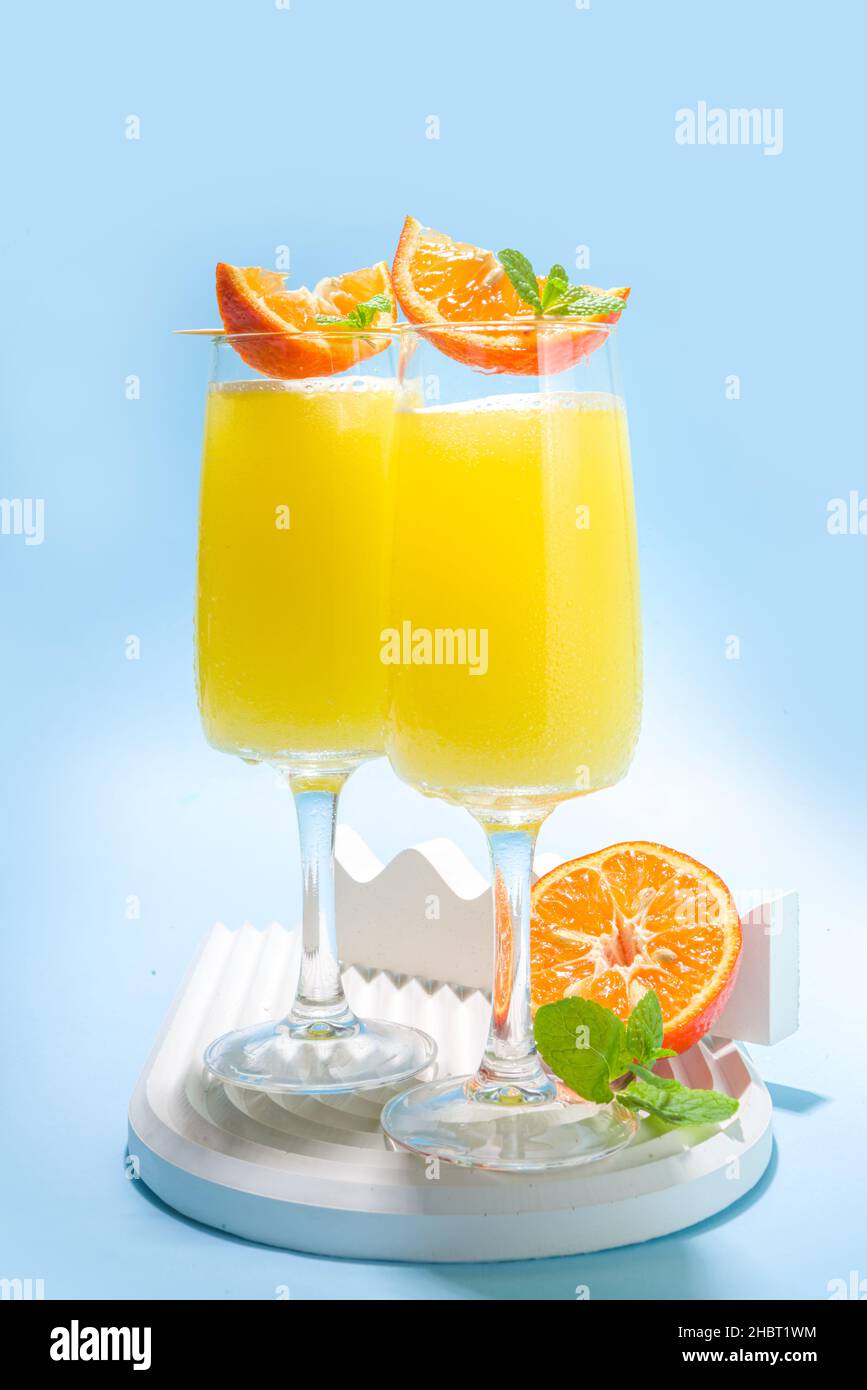 Classic summer mimosas cocktail, with orange juice, on light blue ...