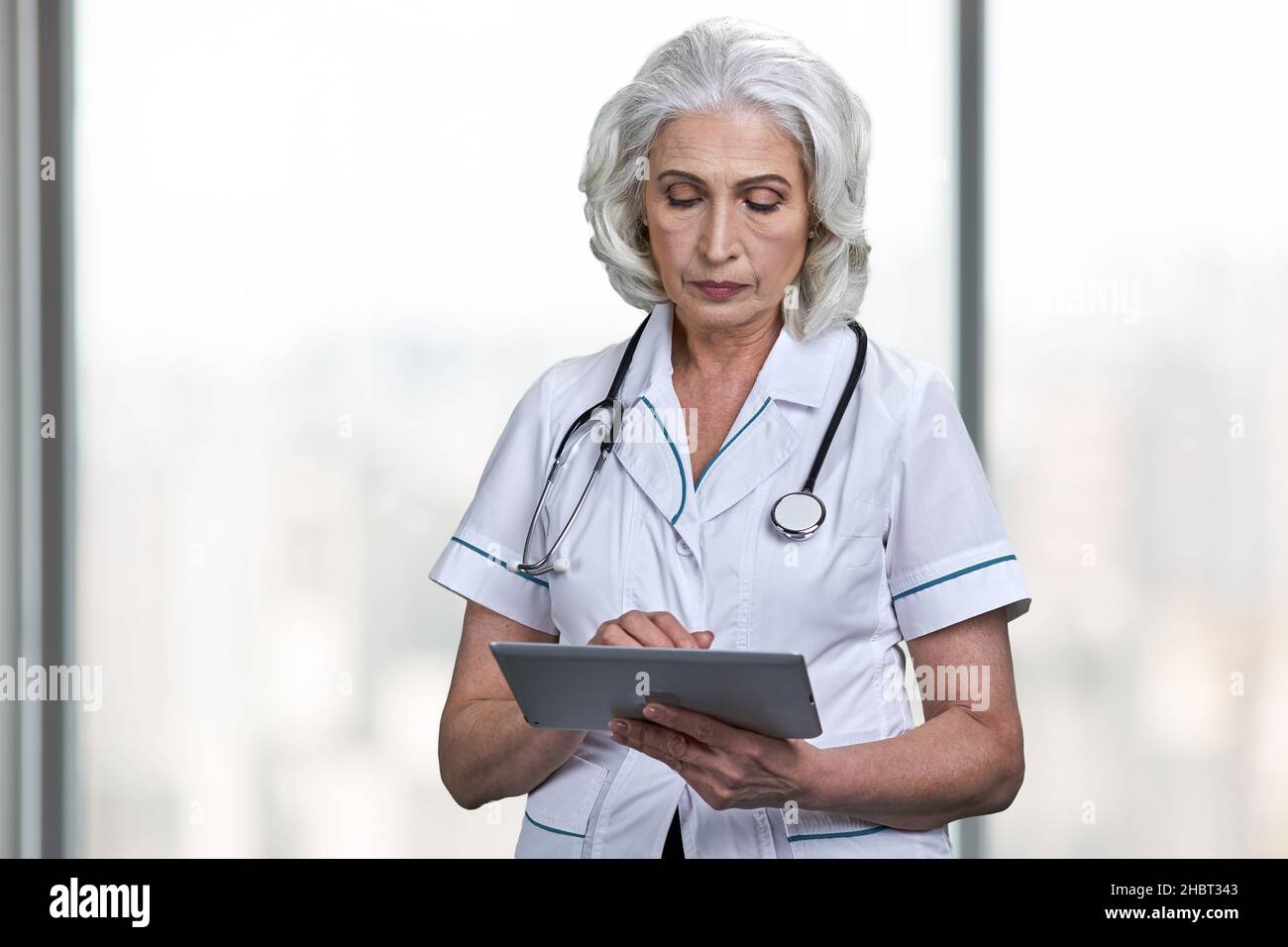 Senior woman doctor using stethoscope hi-res stock photography and ...