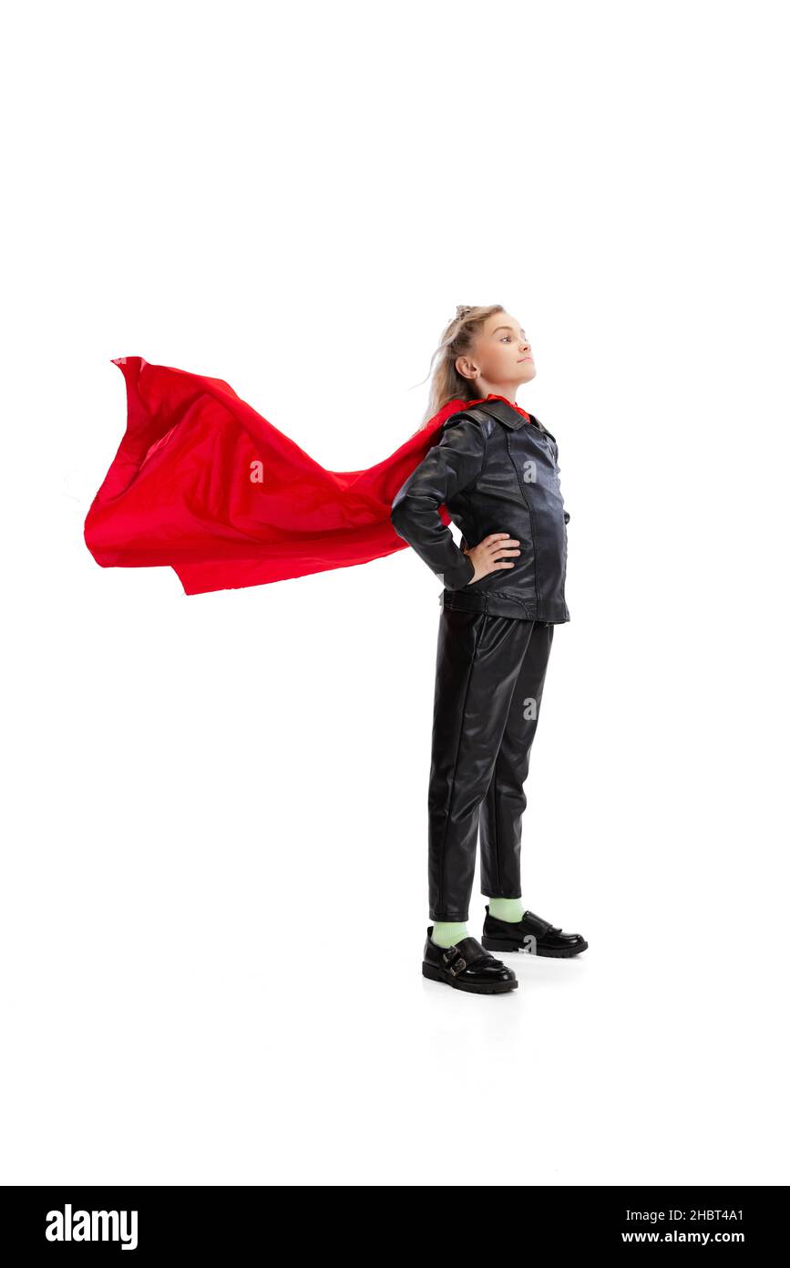 One cute little girl wearing red cape and black costume standing ...