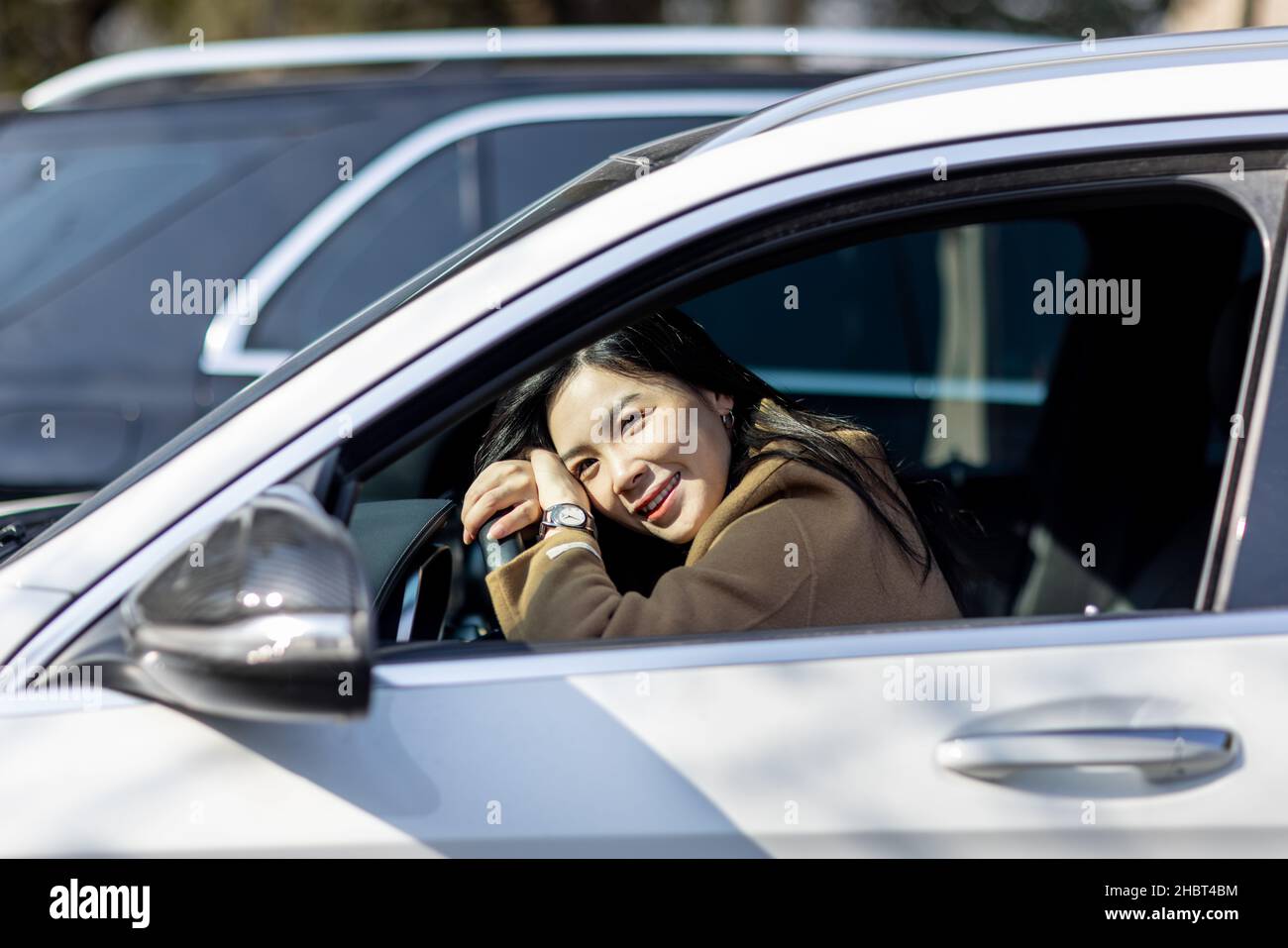 Happy millennial asian woman holding steering wheel when driving car at ...