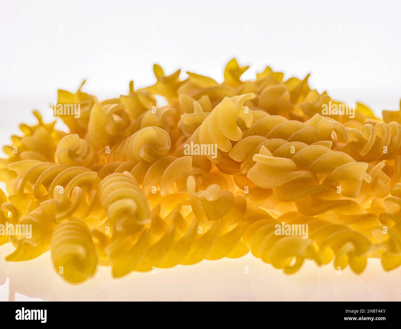 Macro food still life of Fusilli, fuˈzilli, pasta on plain background ...