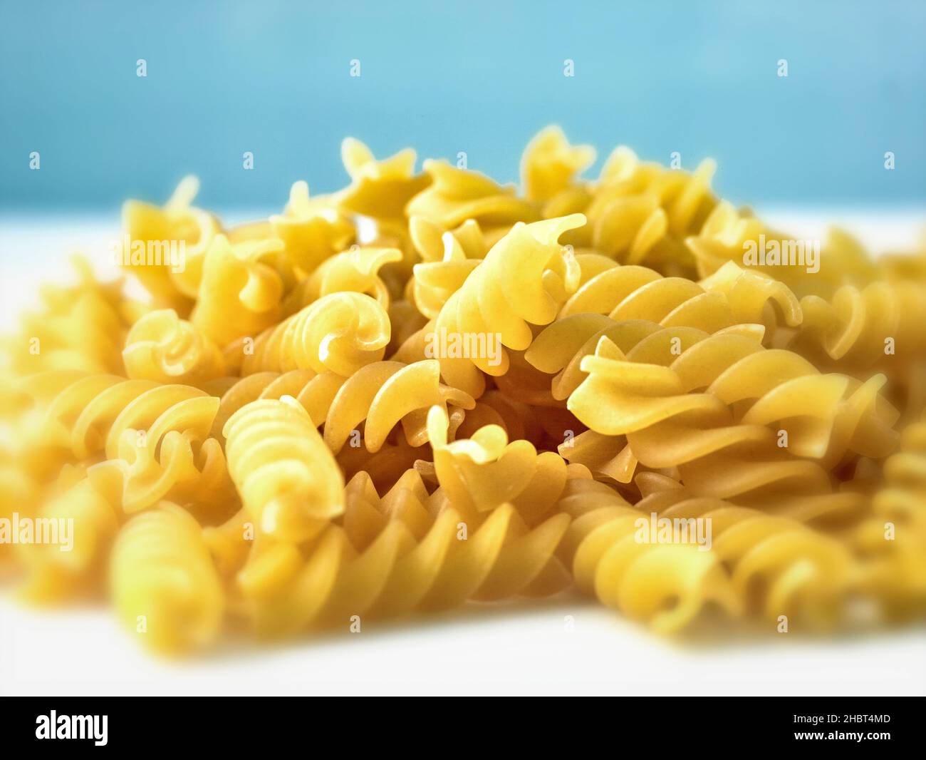 Macro food still life of Fusilli, fuˈzilli, pasta on plain background ...