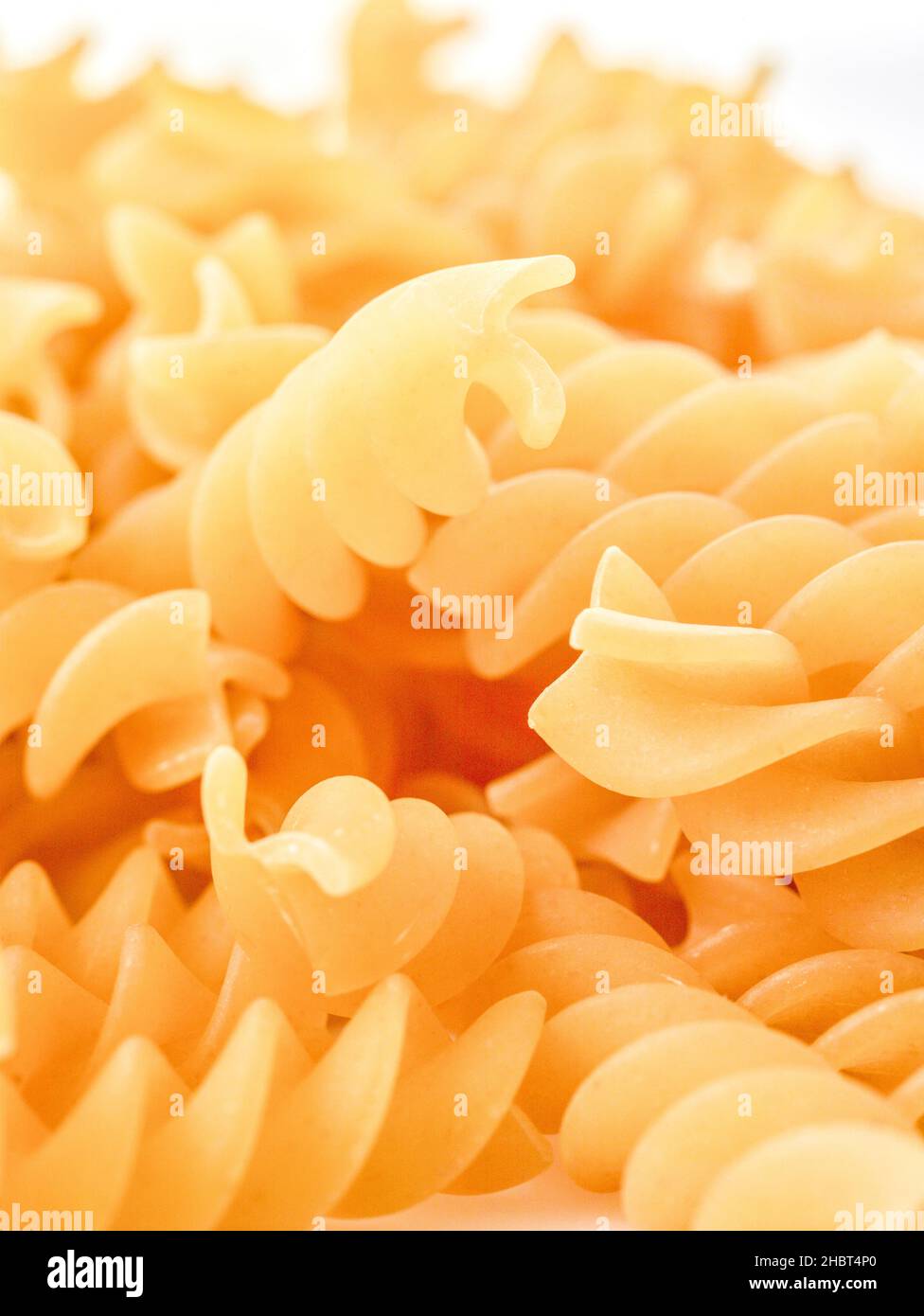 Macro food still life of Fusilli, fuˈzilli, pasta on plain background ...