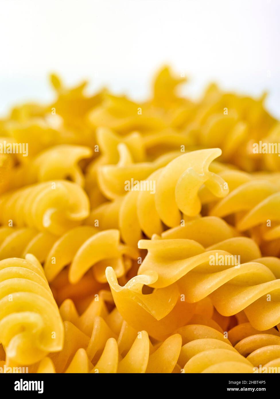 Macro food still life of Fusilli, fuˈzilli, pasta on plain background ...