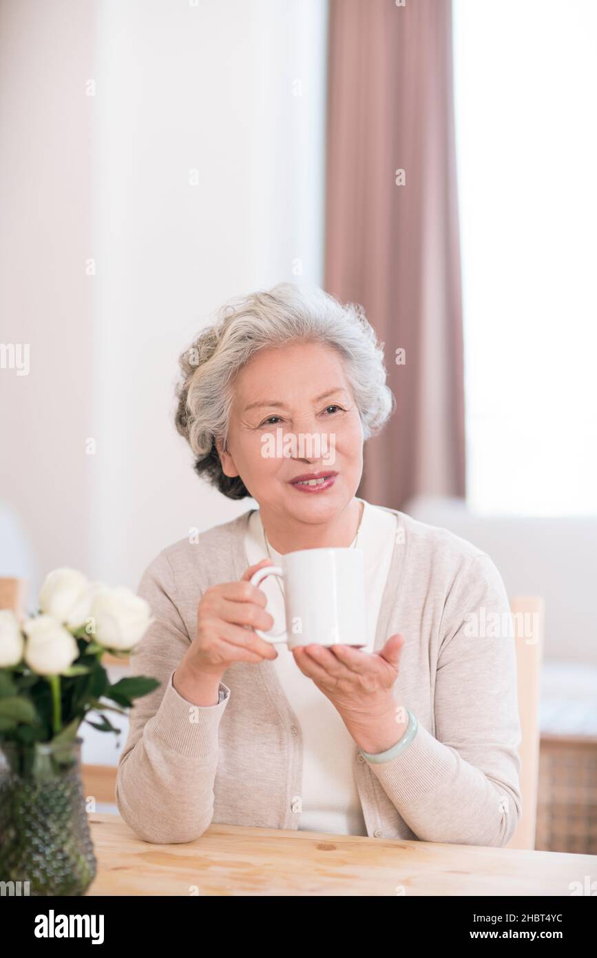 Happy old woman drinking tea at home Stock Photo - Alamy