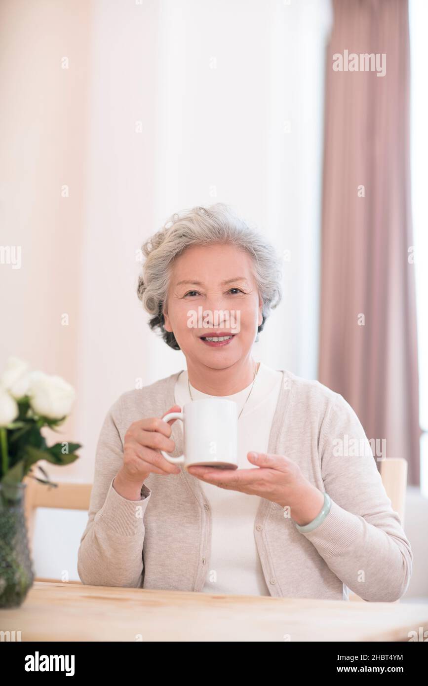 Happy old woman drinking tea at home Stock Photo - Alamy