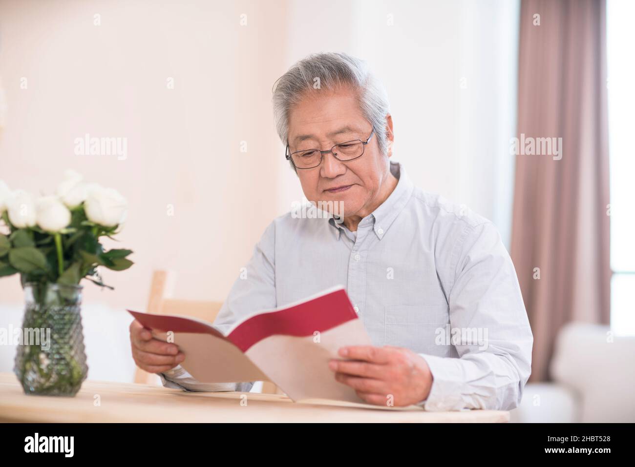 Old man reading on the desk Stock Photo - Alamy