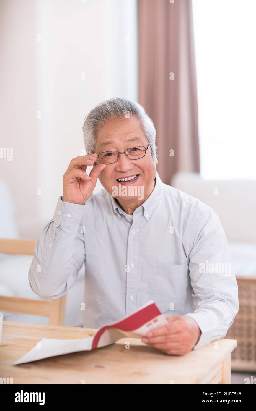 Old man reading on the desk Stock Photo - Alamy