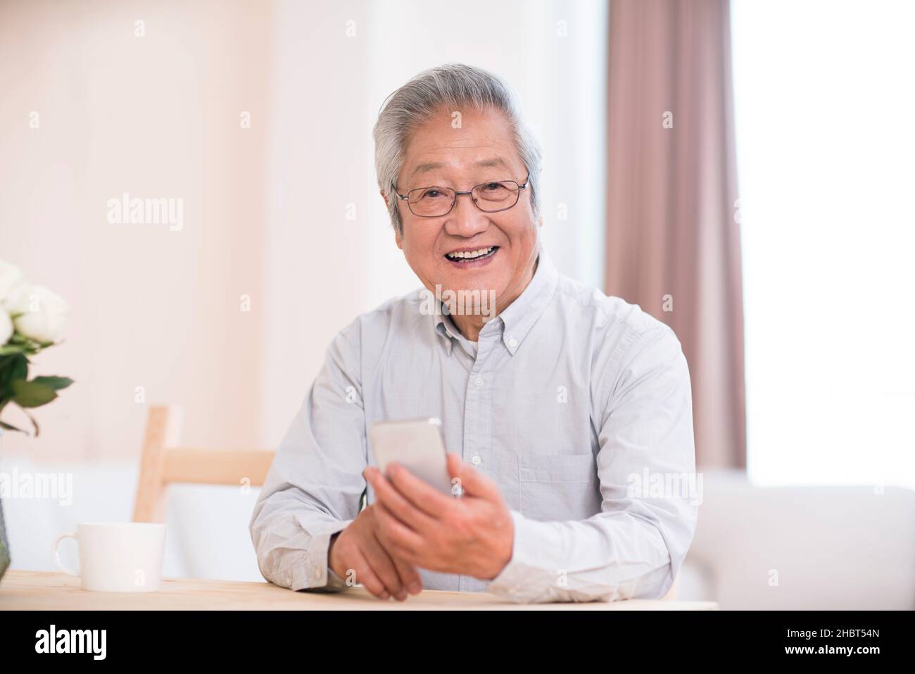 Old man using a smartphone at home Stock Photo - Alamy