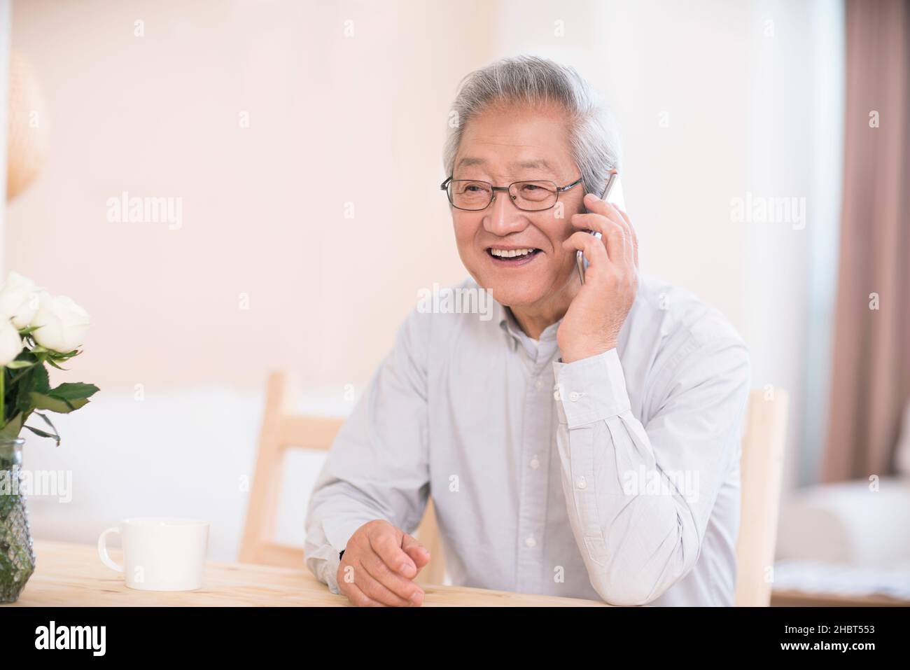 Elderly man using a smart phone to make calls at home Stock Photo - Alamy