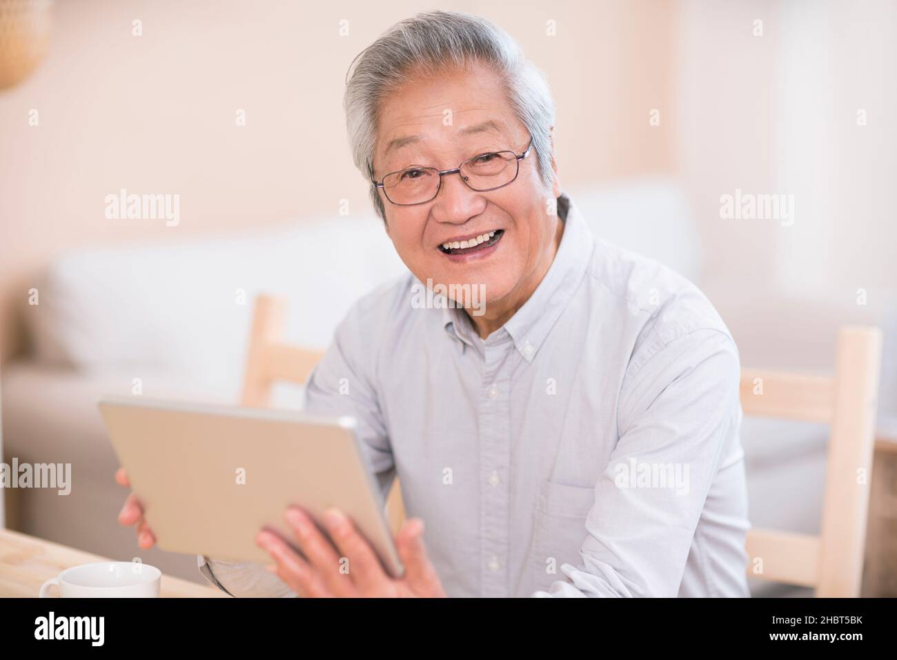 Old man using a tablet computer at home Stock Photo - Alamy