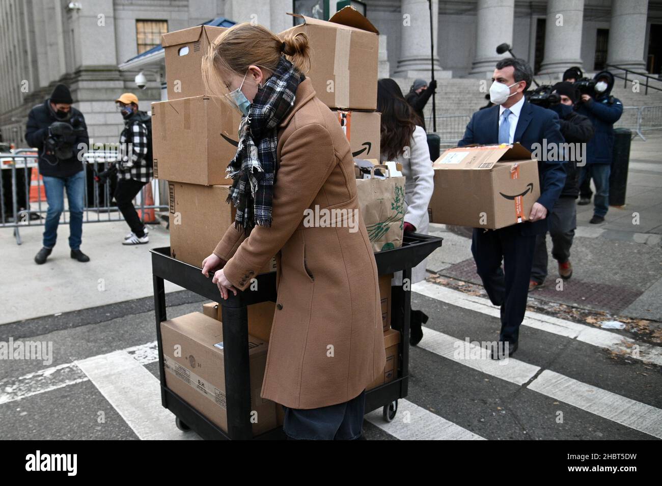 Defense counsel Christian Everdell (white mask) holds a box behind ...