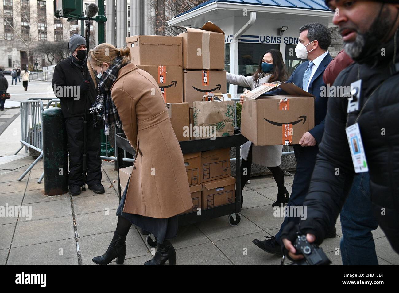 Defense counsel Christian Everdell (white mask) holds a box behind ...