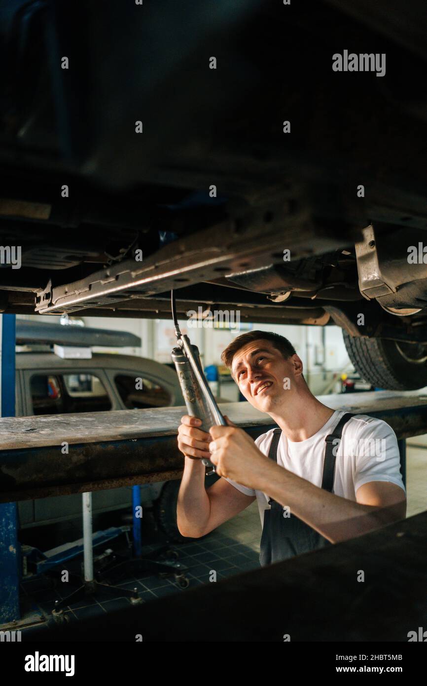 Vertical portrait of serious handsome professional male car mechanic in ...