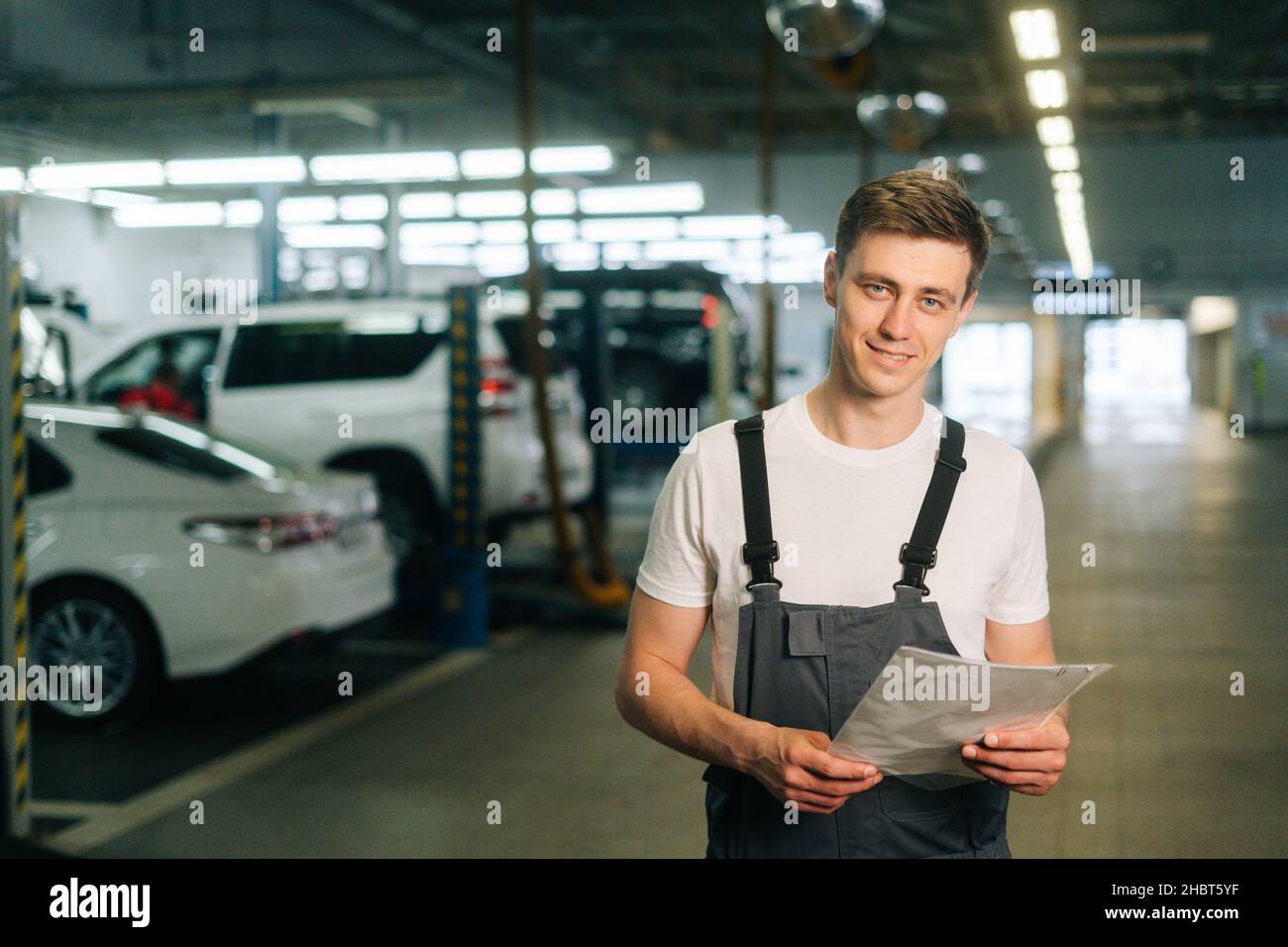 Medium shot portrait of smiling handsome young mechanic male wearing ...