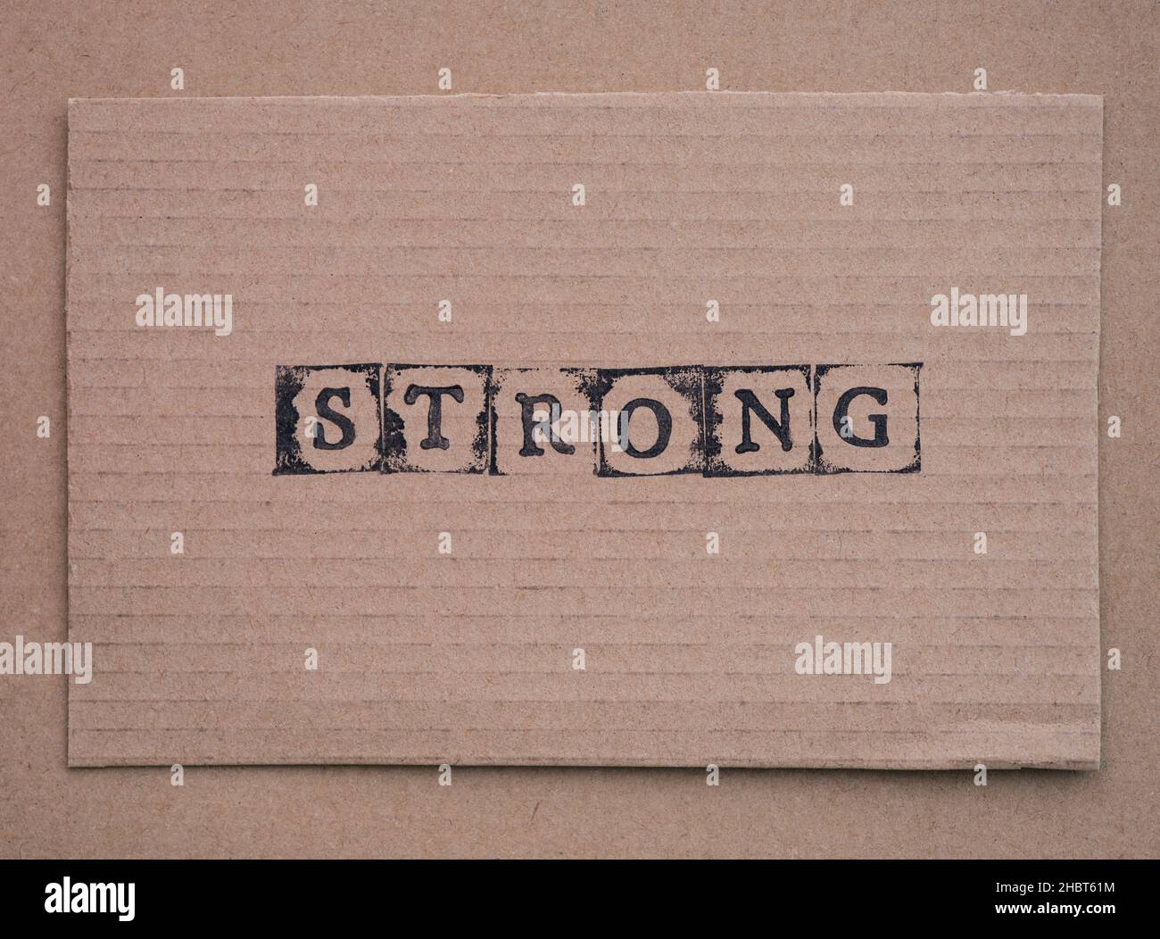 Cardboard with word Strong made by black alphabet stamps Stock Photo ...