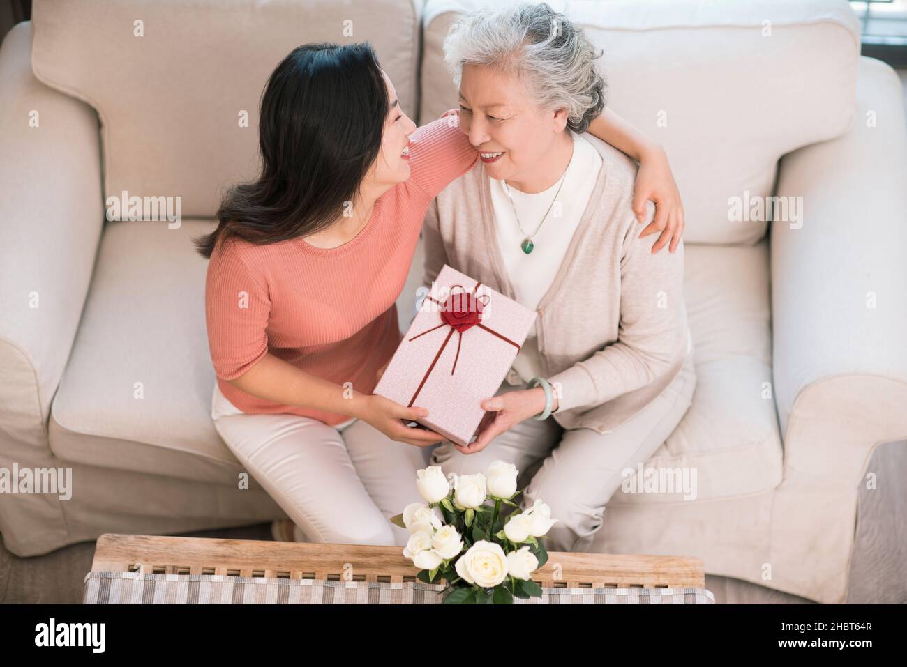 Daughter giving her mother a present Stock Photo - Alamy