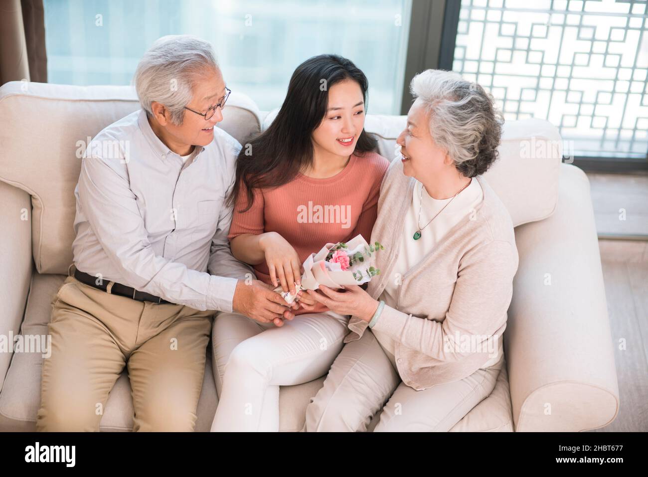Daughter giving her parents flowers Stock Photo - Alamy