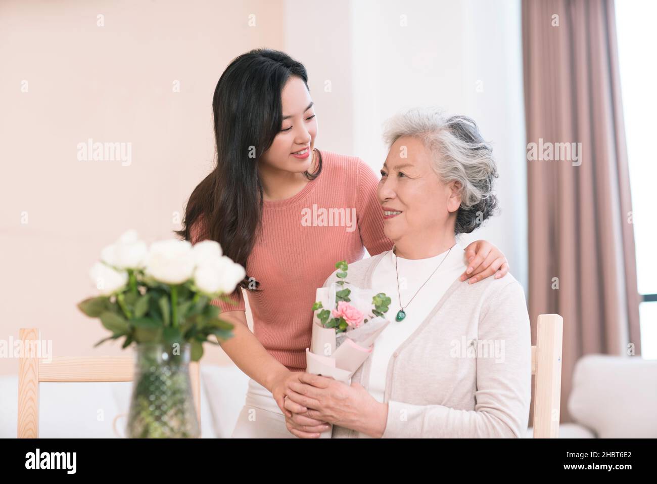 Daughter giving her mother flowers Stock Photo - Alamy