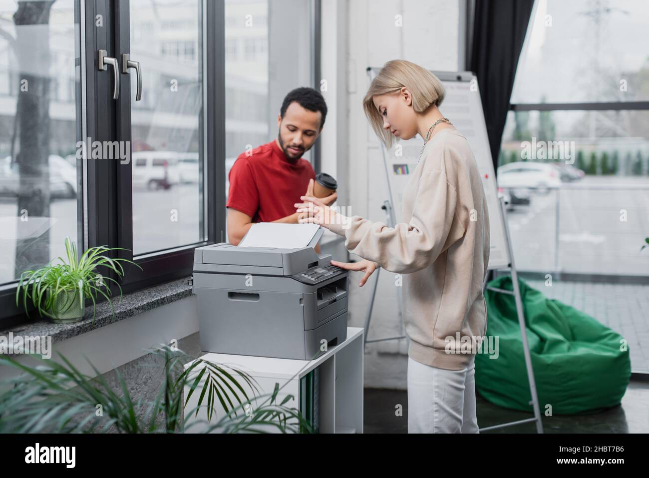 blonde woman copying document near african american manager with paper ...