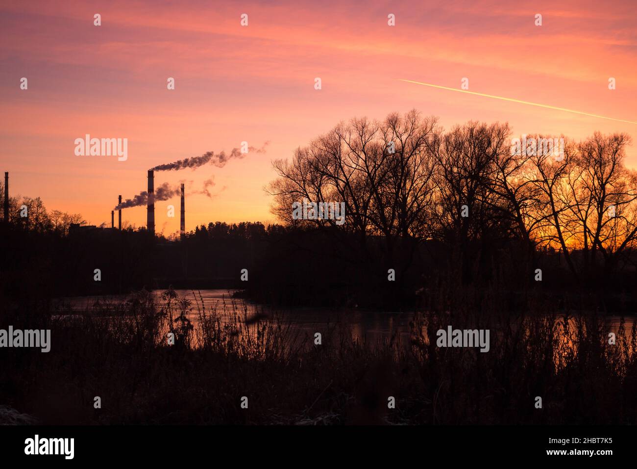Smokestacks and trees on a beautiful sunset background Stock Photo - Alamy