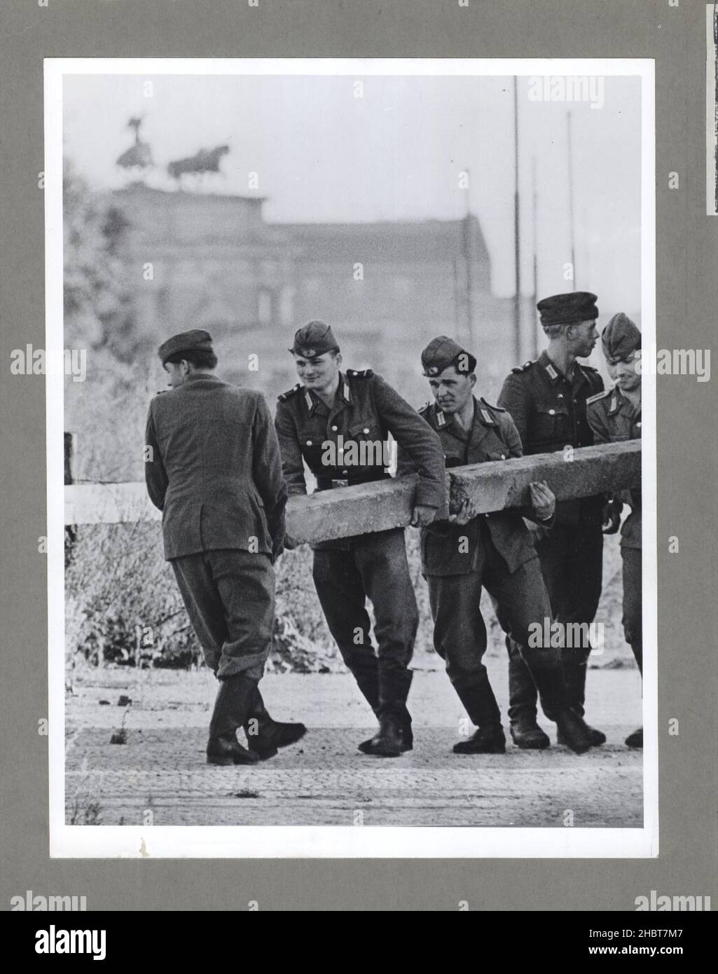 Late August 1961. East German soldiers carry a post for the barbed wire ...
