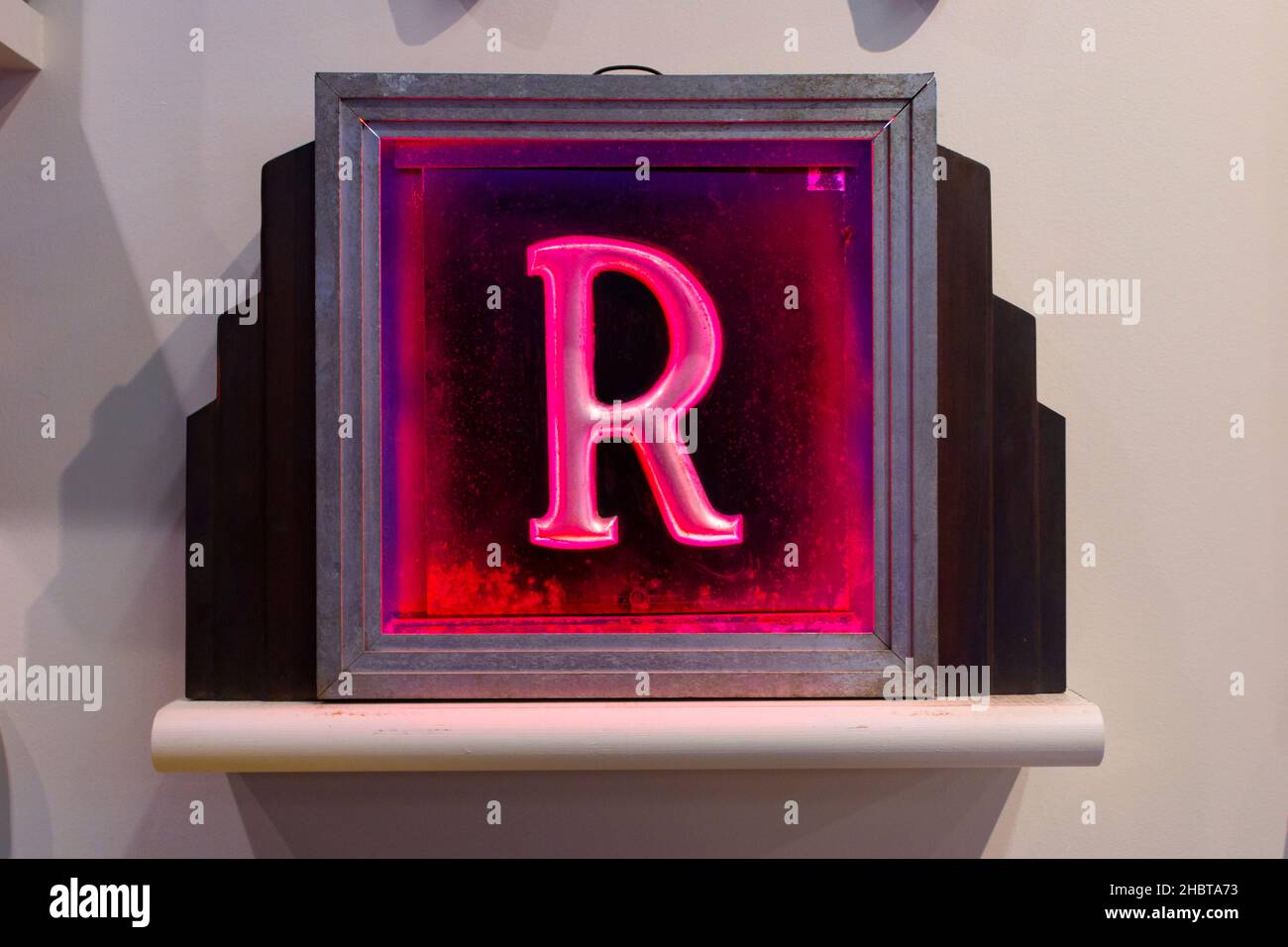 red pink illuminated neon sign of capital letter R Stock Photo - Alamy