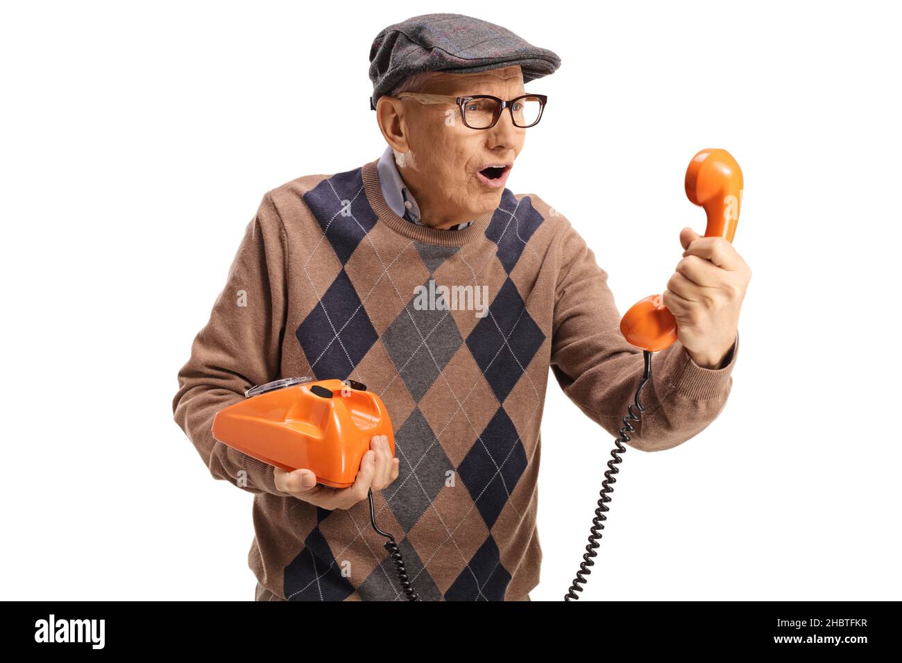 Elderly man holding an old vintage rotary phone and looking at the ...