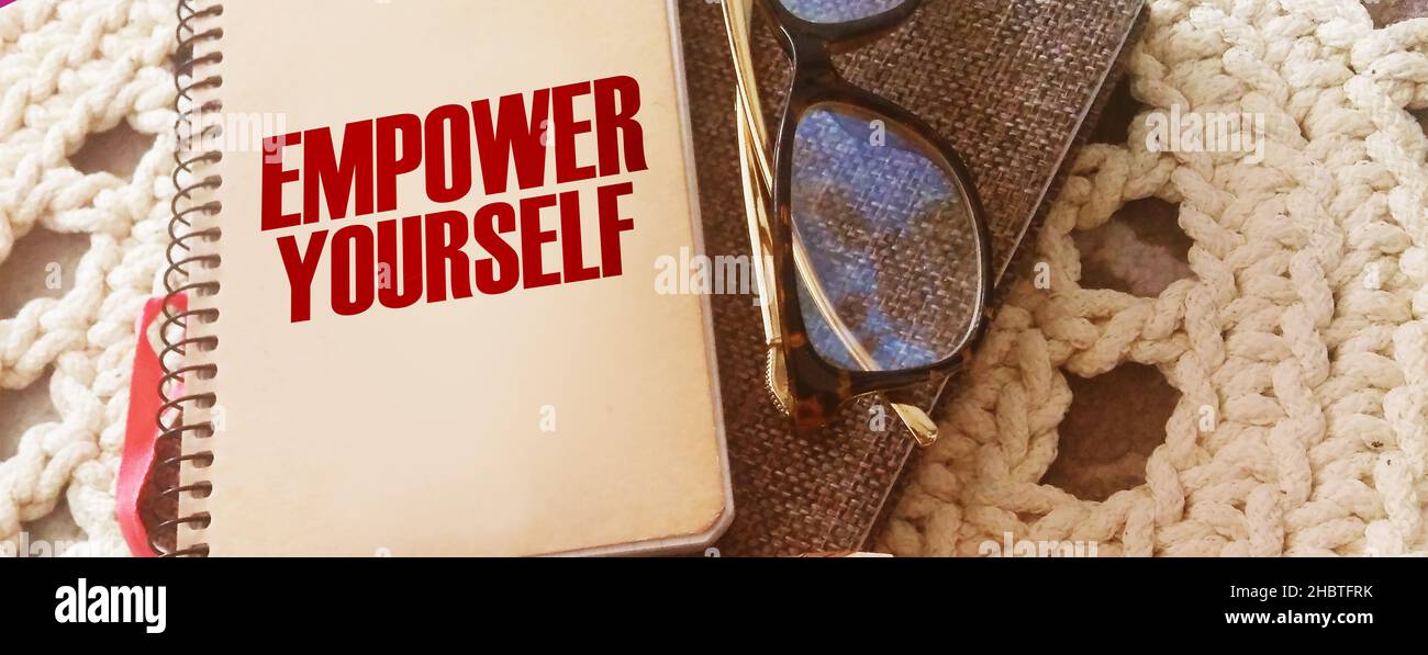 Empower Yourself words on book cover with eyeglasses and pen. Business ...