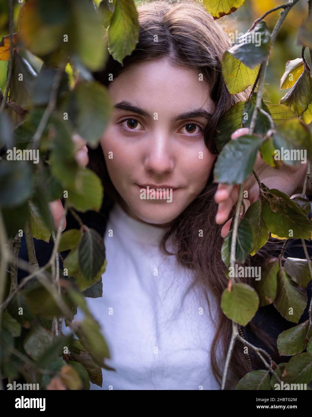 Teenage Woman Standing Surrounded by Trees Stock Photo - Alamy