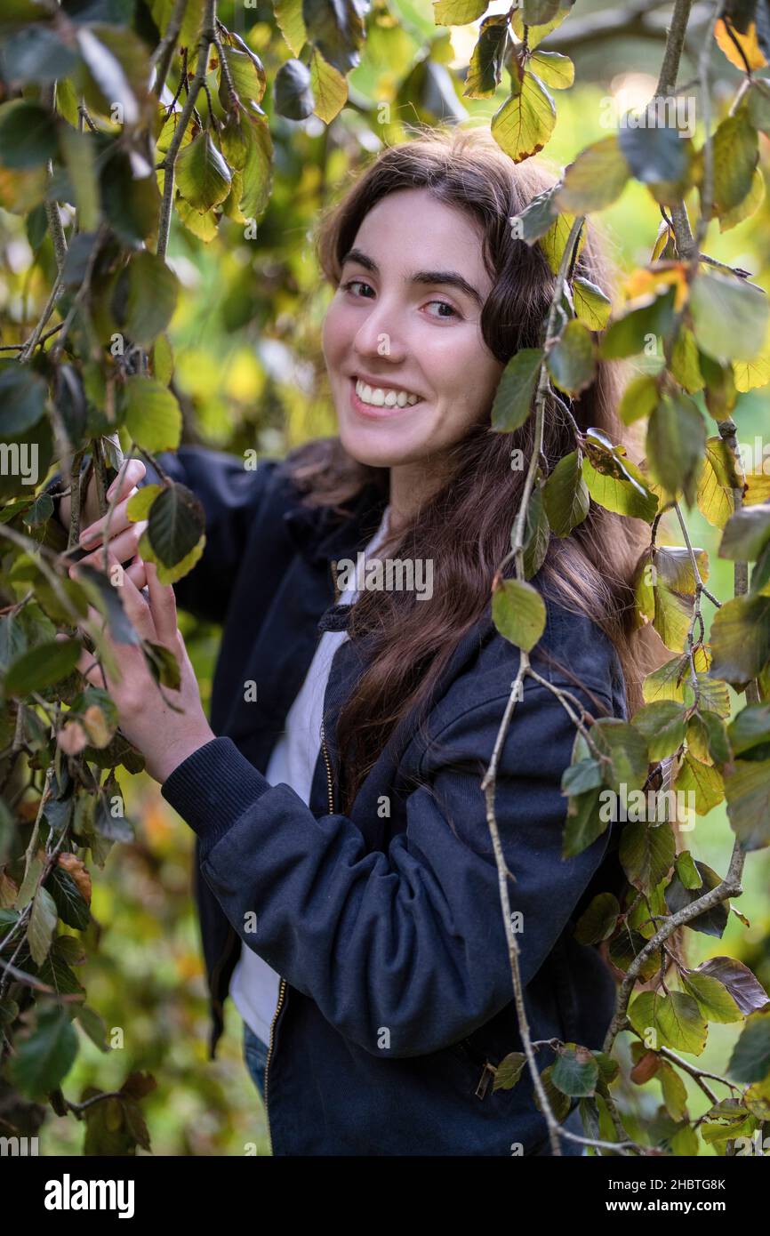 Teenage Woman Standing Surrounded by Trees Stock Photo - Alamy