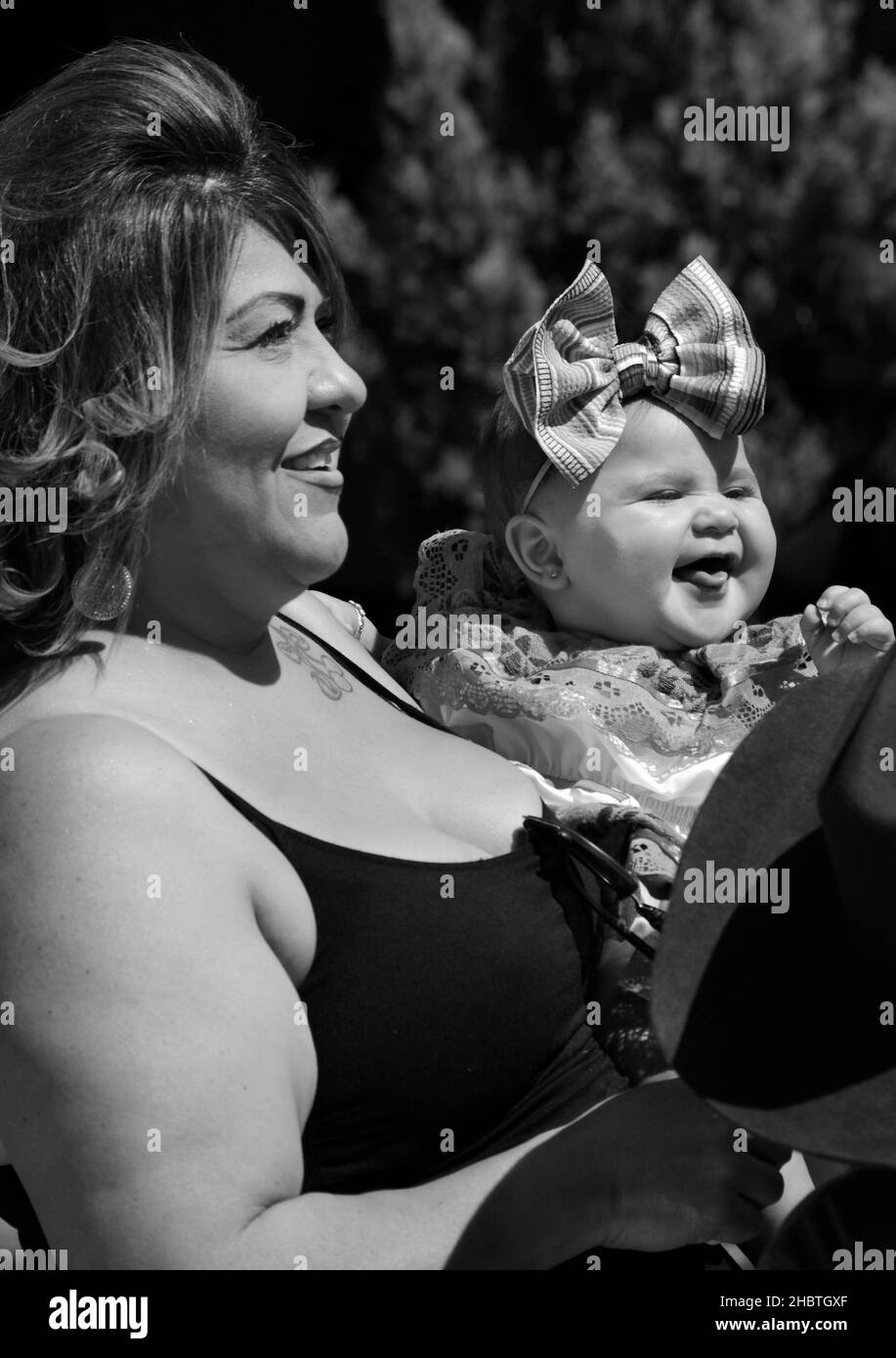 A woman proudly shows off her baby at an outdoor Hispanic festival in ...