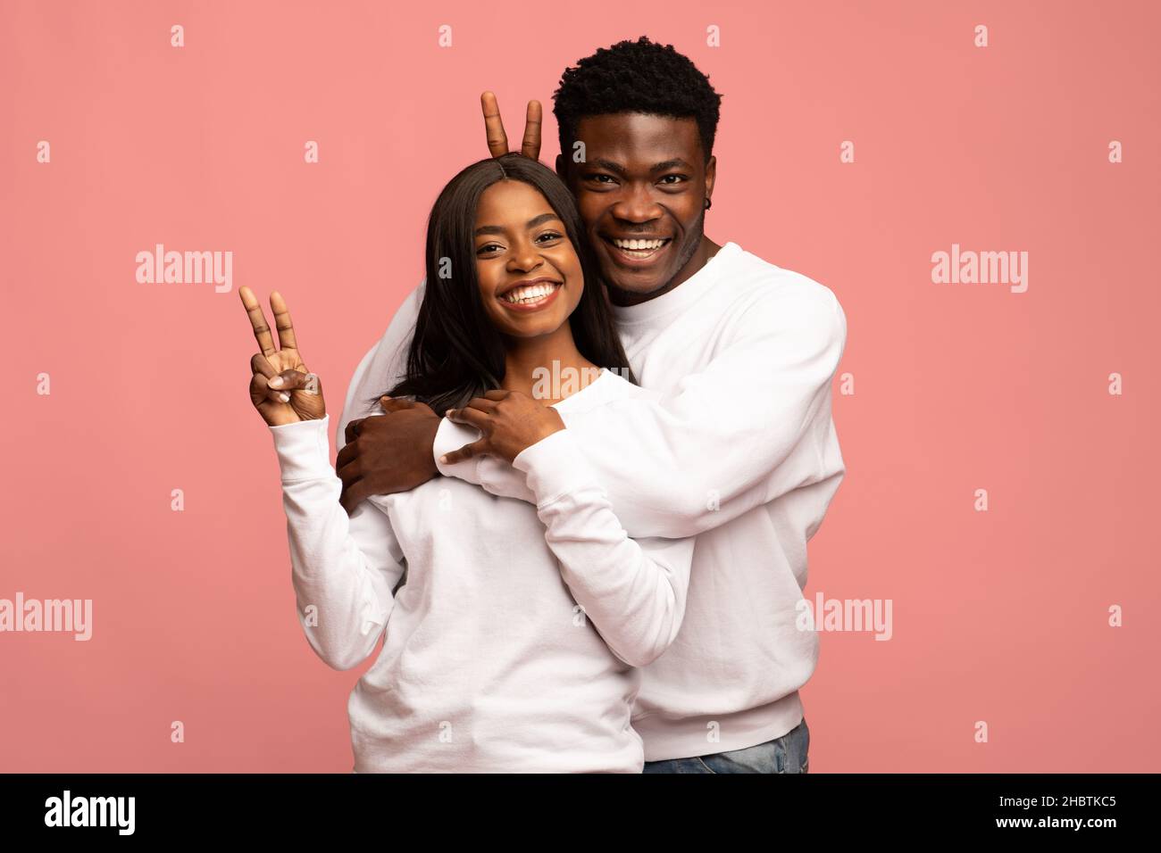 Beautiful african american couple cuddling on pink studio background ...