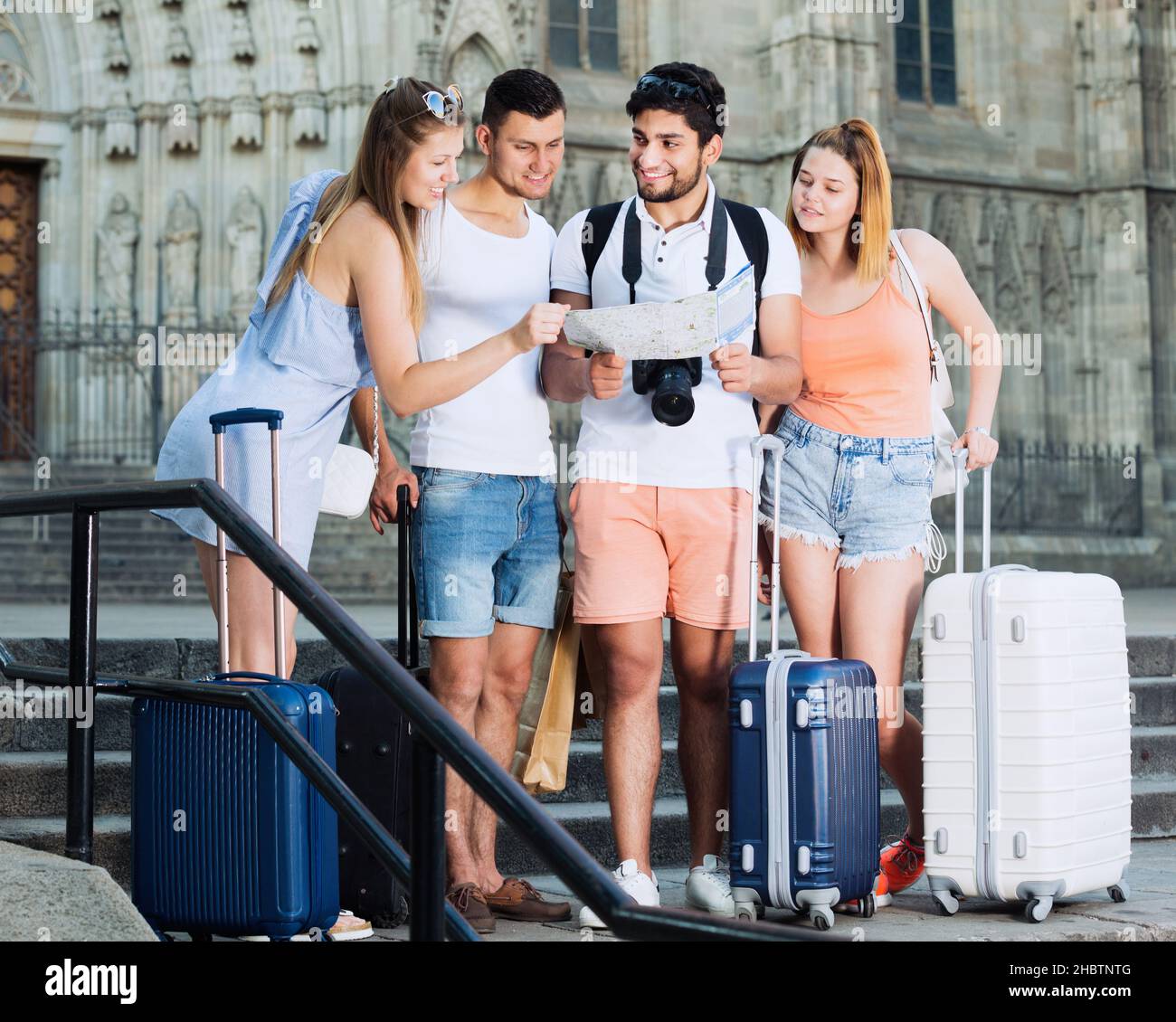 Group of young travellers searching for direction using map Stock Photo ...
