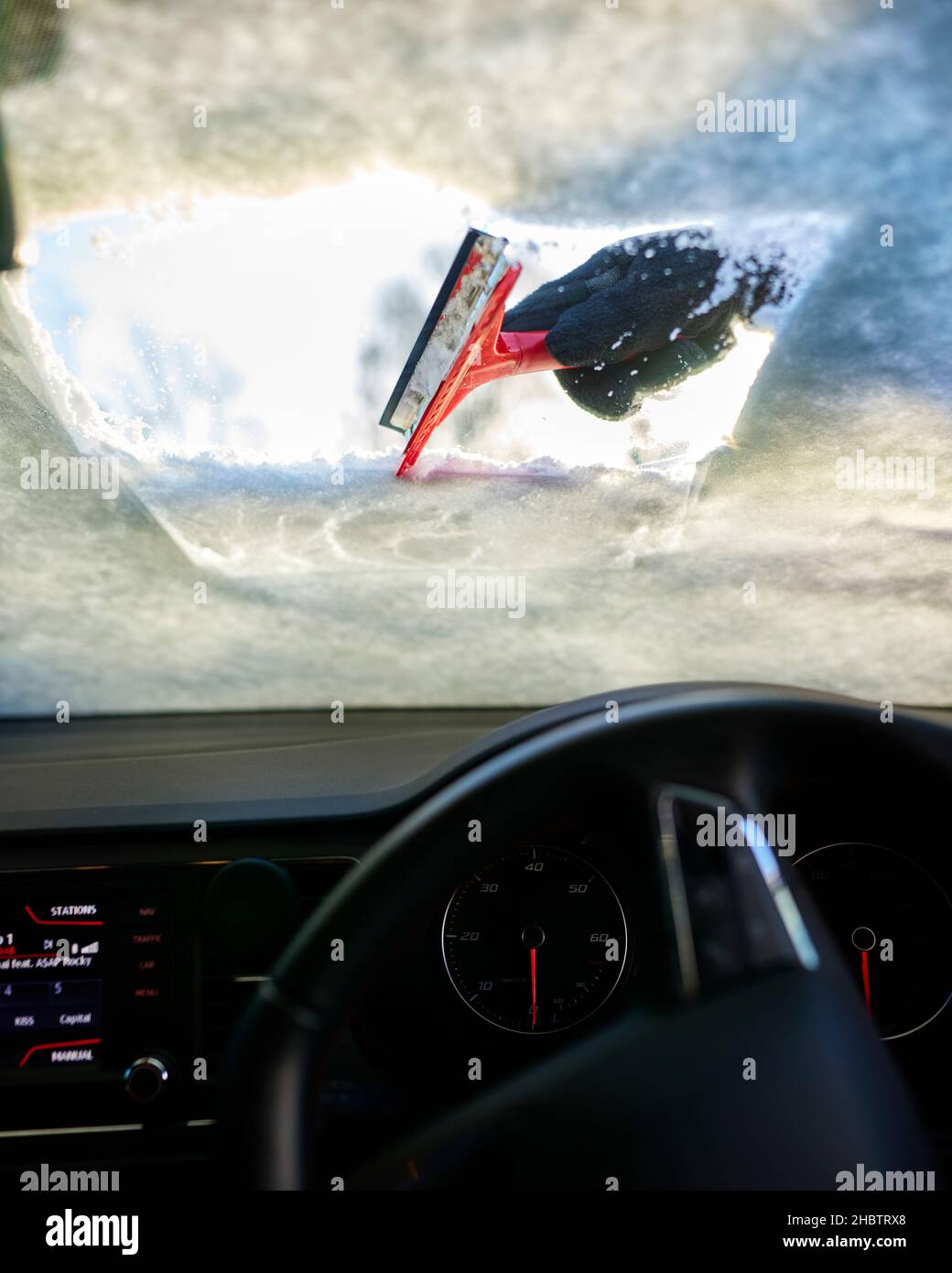 Driver clearing snow from windscreen Stock Photo - Alamy