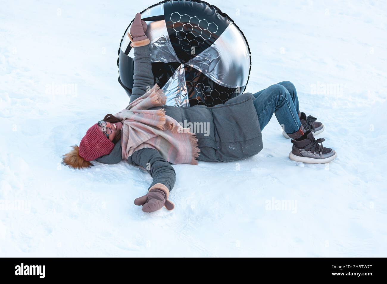 Young woman with snow tubing winter activity, slide from snow hi Stock ...