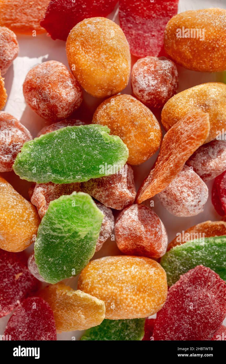 Bright colored candied fruits in the form of petals and squares close ...