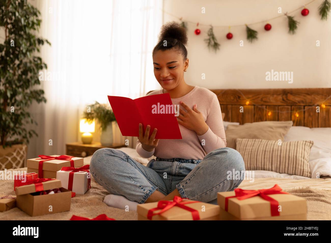 Congratulation with xmas holidays. Happy black lady reading greeting ...