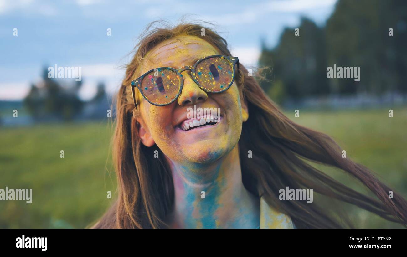 Cheerful girl posing smeared in multi-colored powder Stock Photo - Alamy