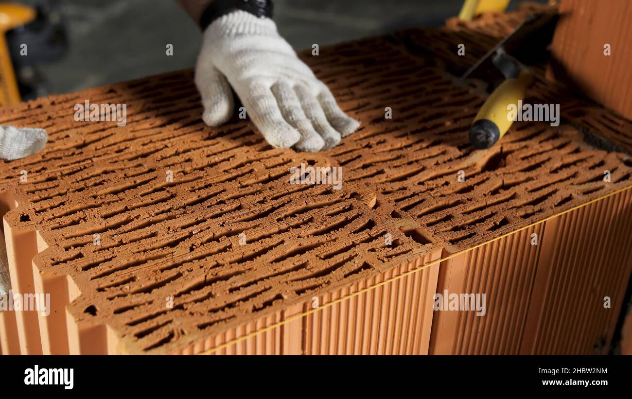 Industrial bricklayer worker placing bricks on cement while building ...