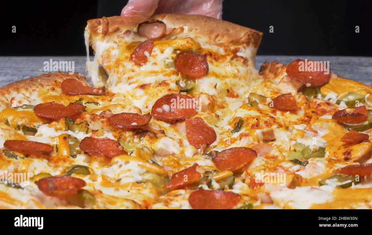 Close up for hand taking a slice of pizza with stretching mozzarella on ...