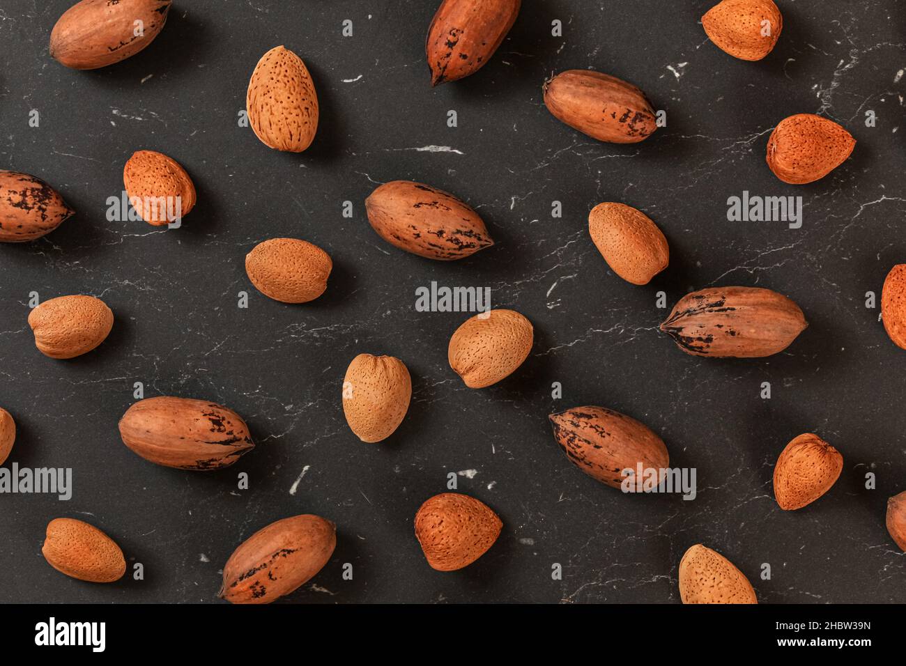 Mixed whole pecan nuts and almonds on black marble board, flat lay ...