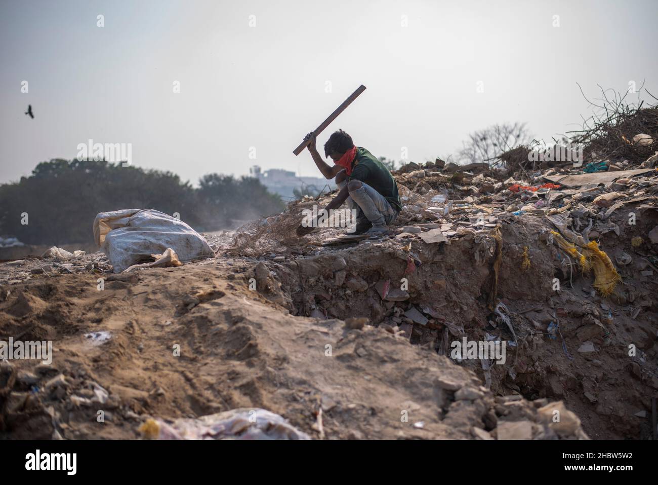 A young rag picker seen searching for reusable items from a Landfill ...