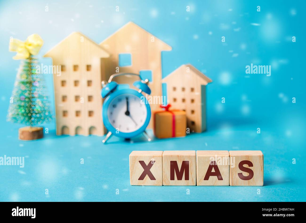 Wooden blocks with the word Xmas, miniature houses, clock and a ...