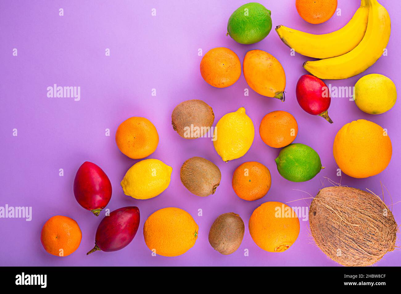 Citrus fruitage and bananas, coco, kiwi on lilac background. Assorted ...