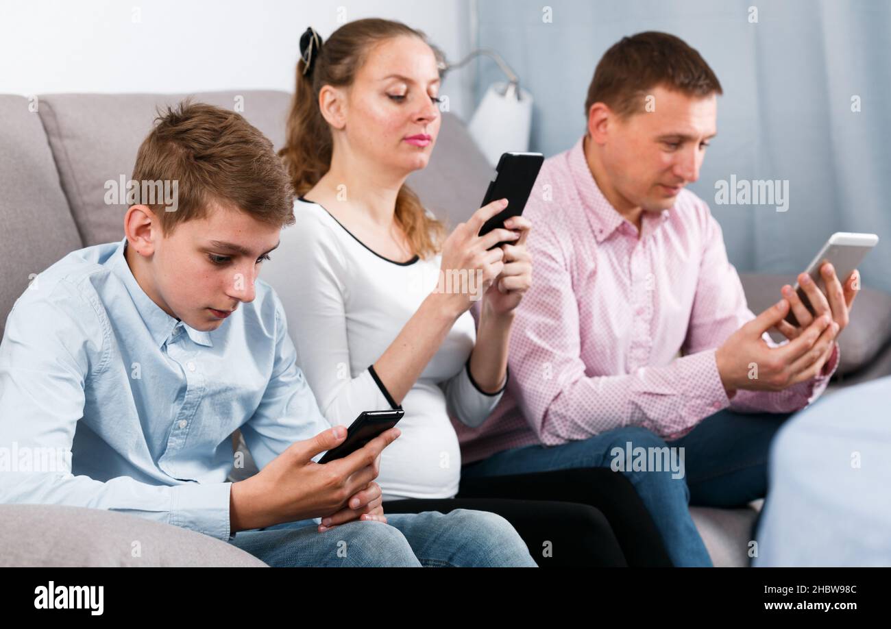 Parents and son using phones Stock Photo - Alamy