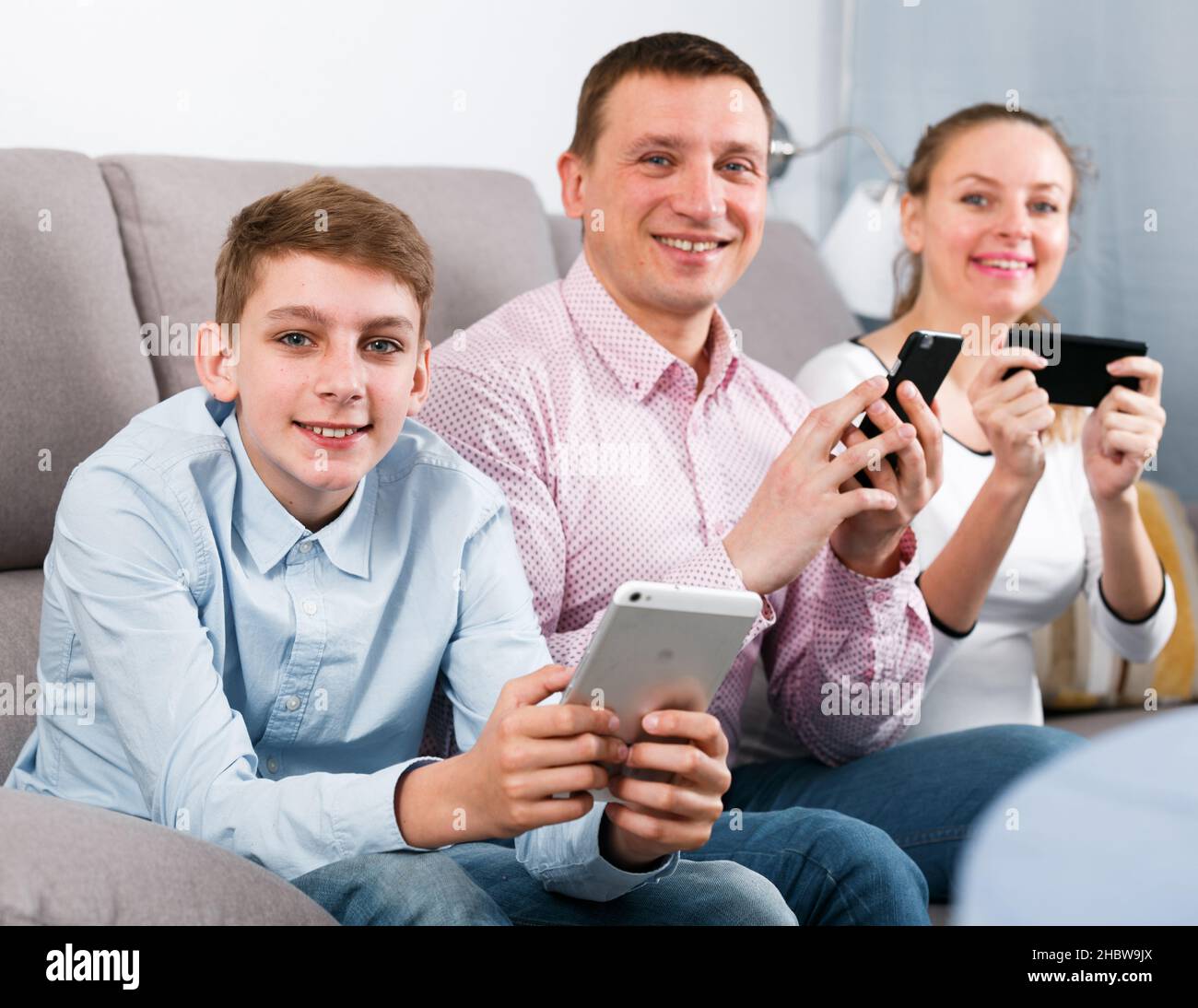 Parents and son using phones Stock Photo - Alamy