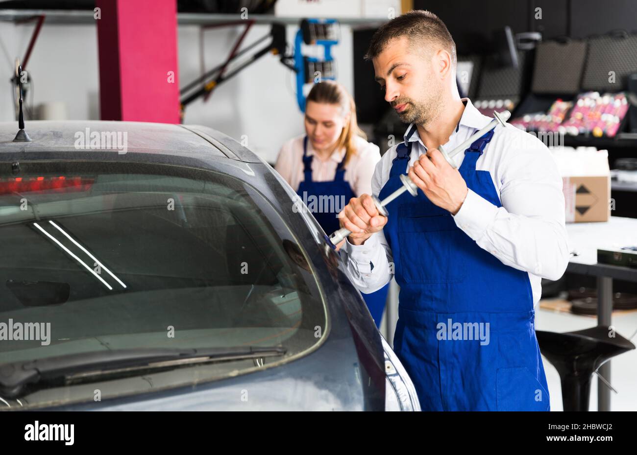 Mechanic performing dent repair Stock Photo - Alamy
