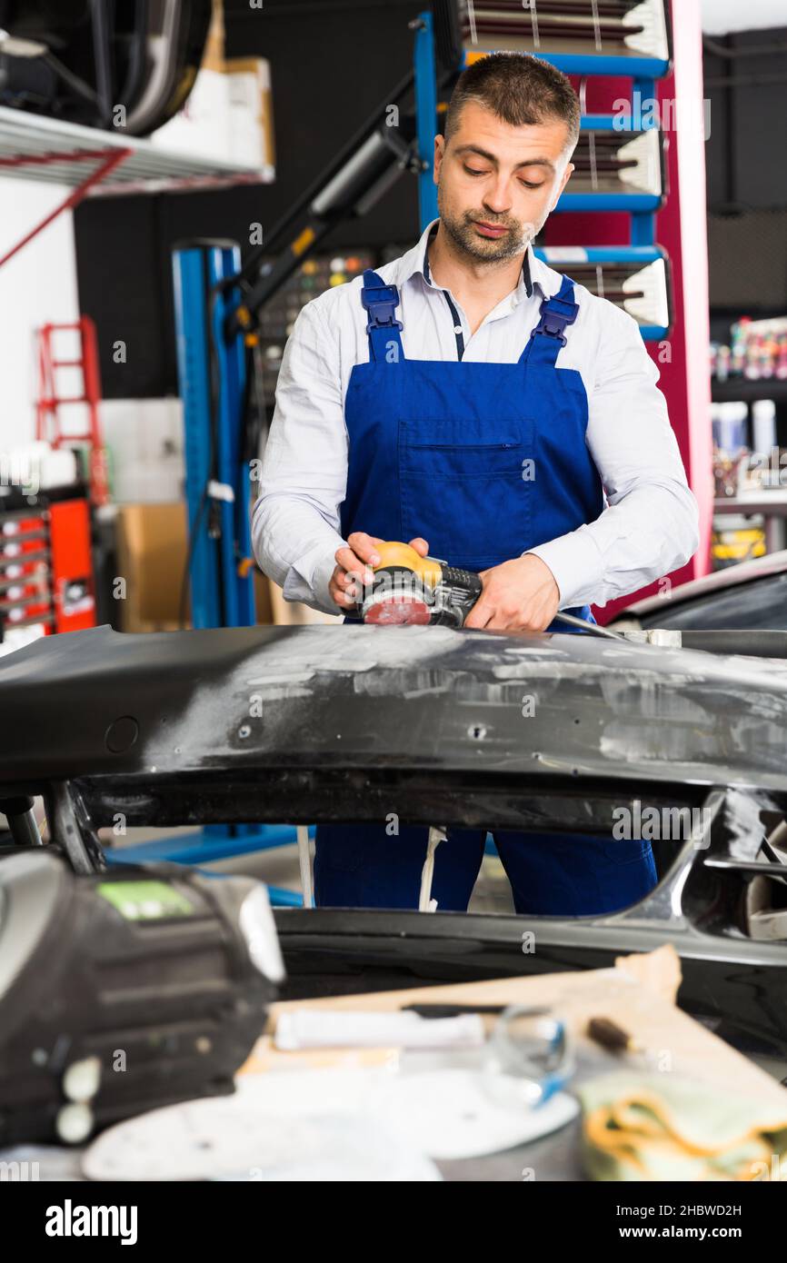 Mechanic grinding car bumper Stock Photo - Alamy